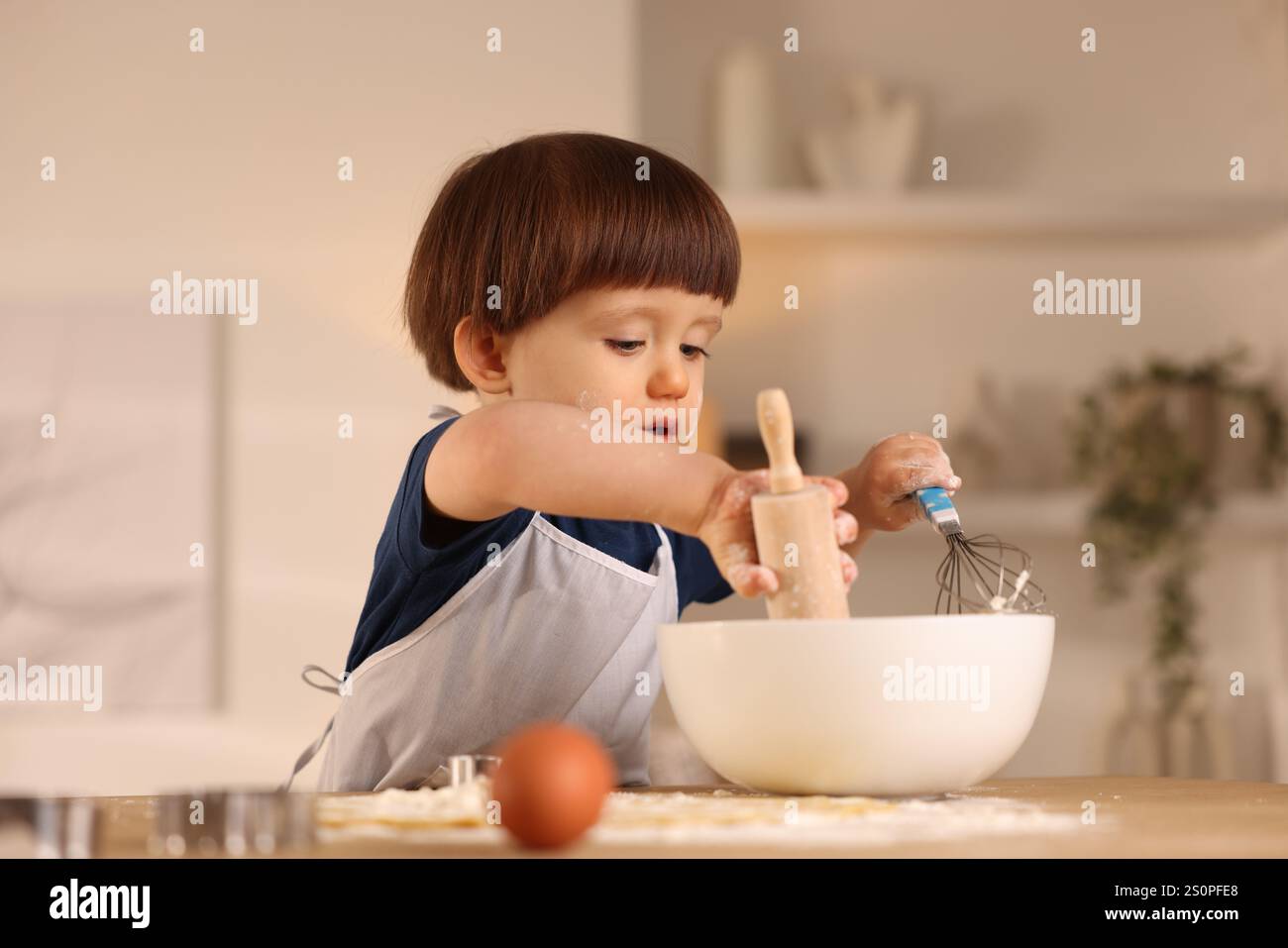Cute little boy making dough at table indoors Stock Photo - Alamy