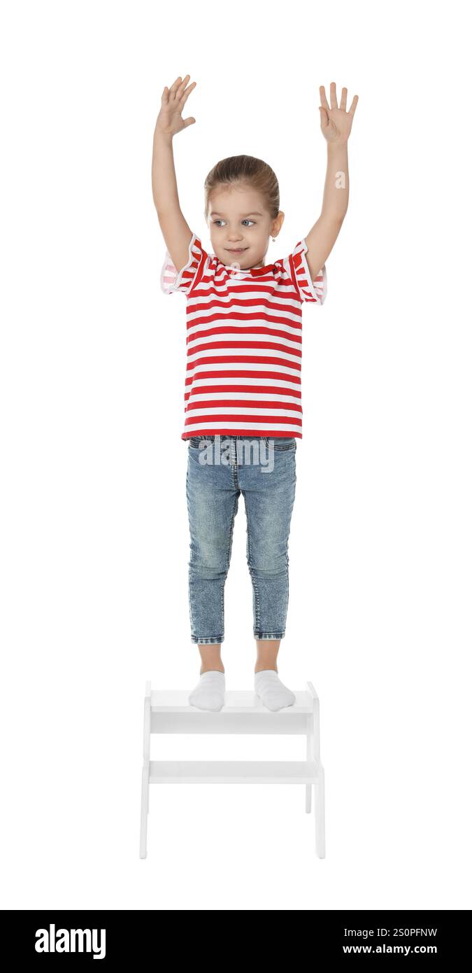 Little girl standing on step stool against white background Stock Photo ...