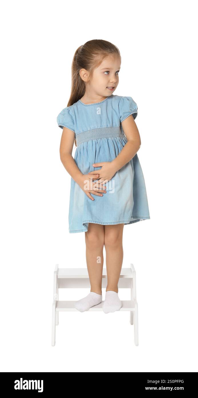 Little girl standing on step stool against white background Stock Photo ...