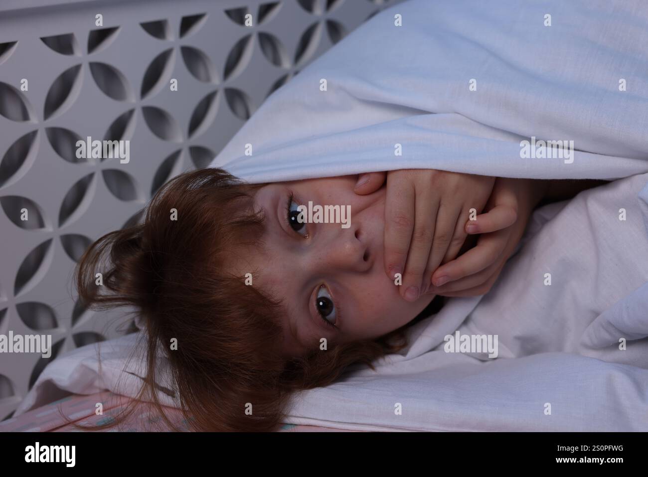Afraid boy under blanket on bed at night Stock Photo - Alamy