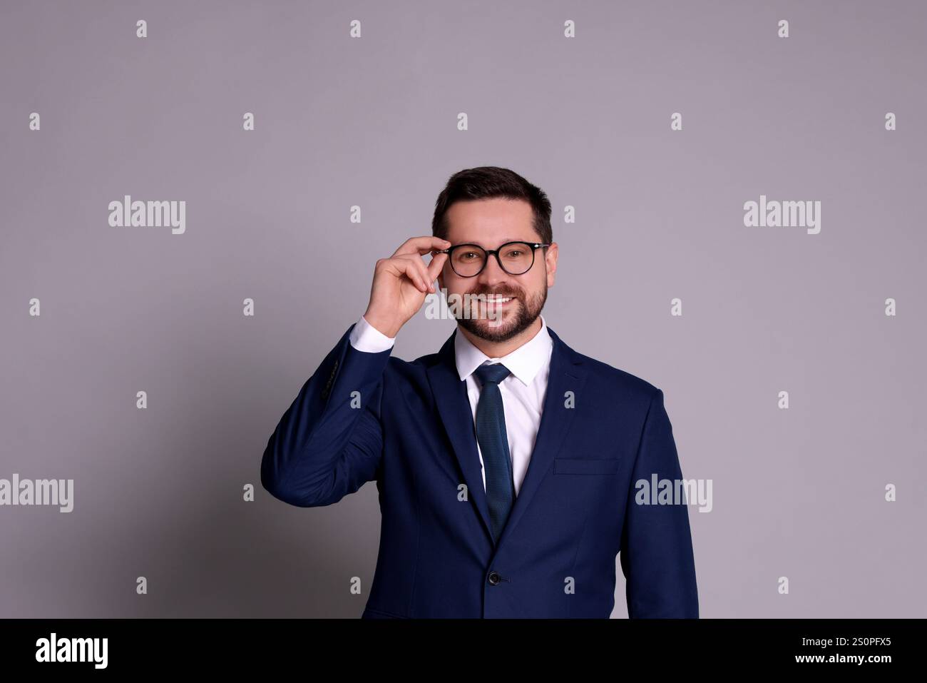 Portrait of banker in glasses on grey background Stock Photo - Alamy