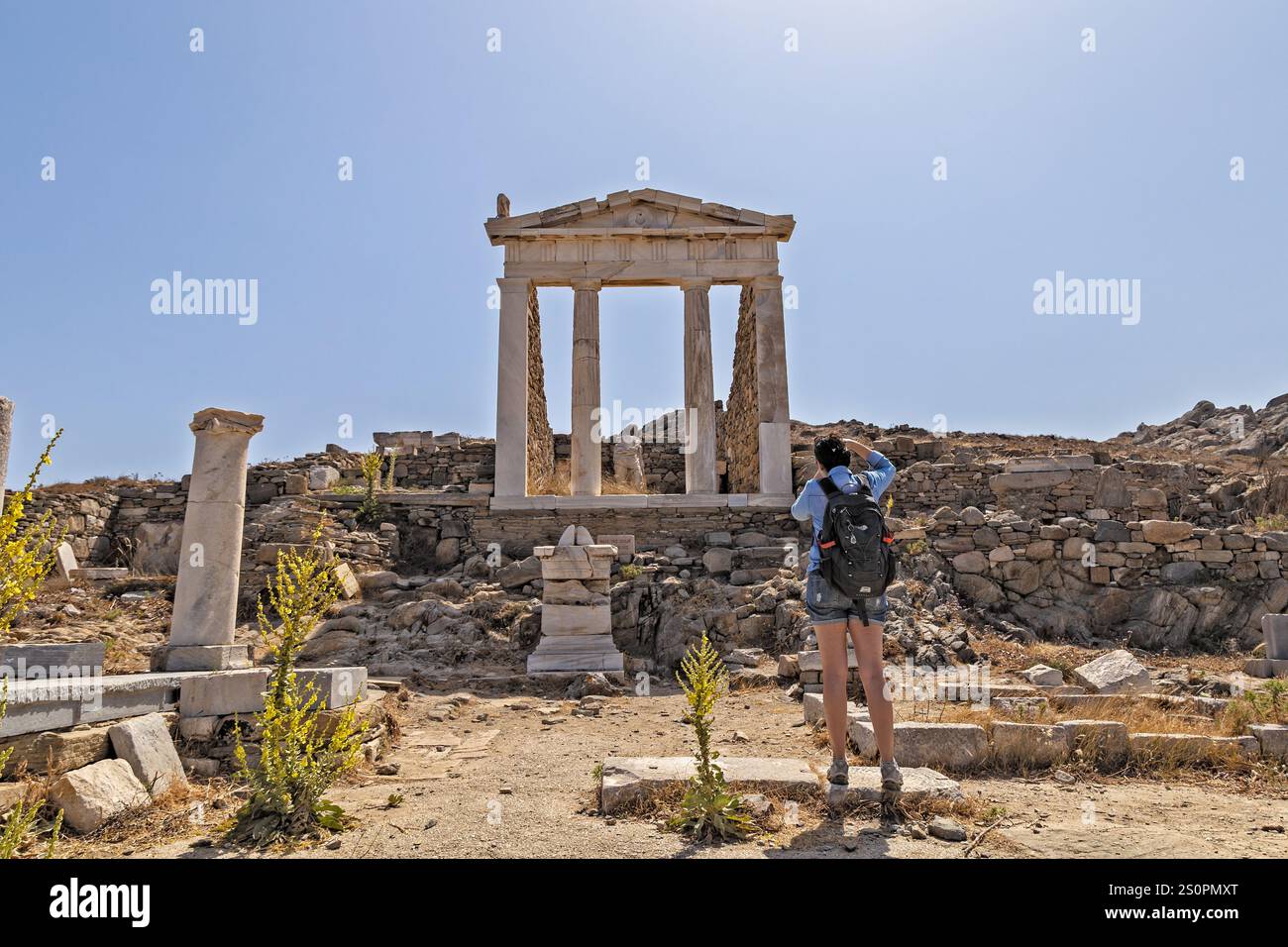 Tourist Exploring Ancient Greek Ruins During Daytime Under Bright Clear ...