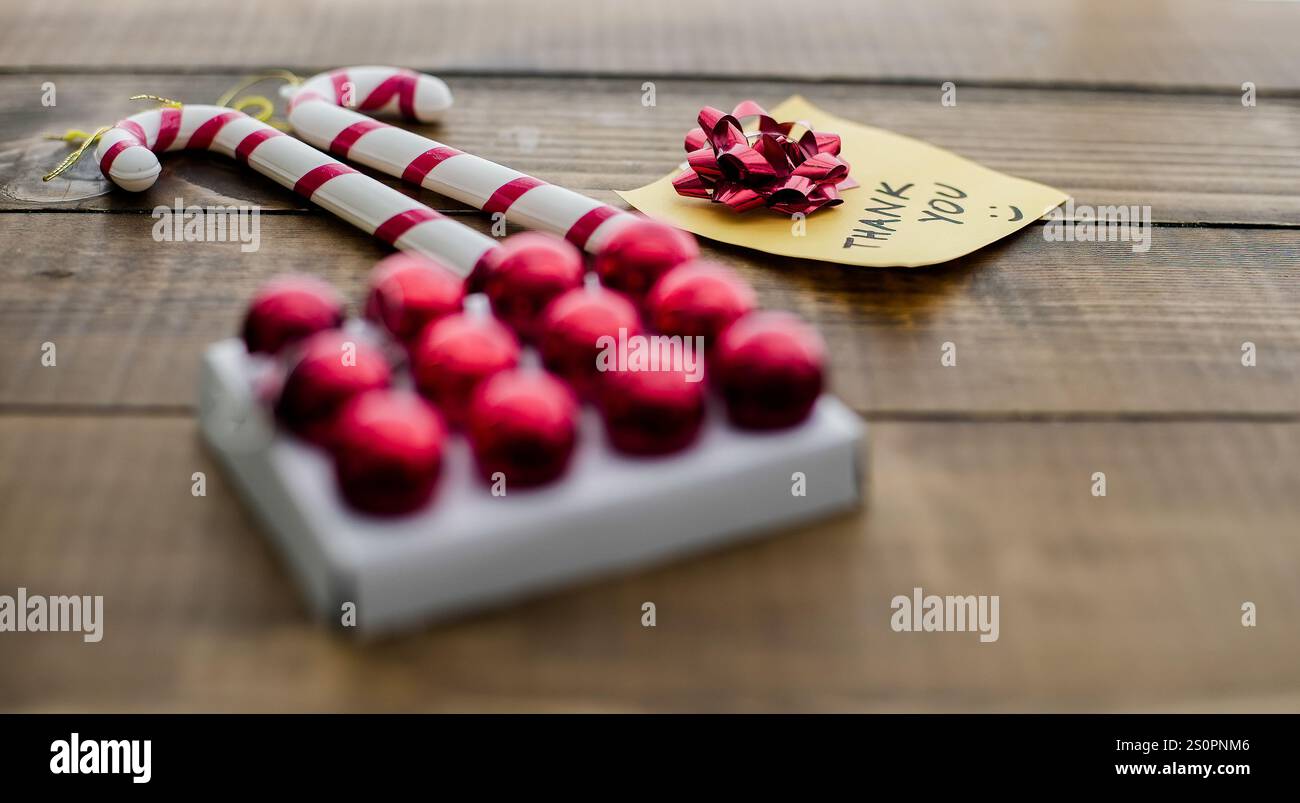 A festive arrangement features red candy canes and a thank you note ...
