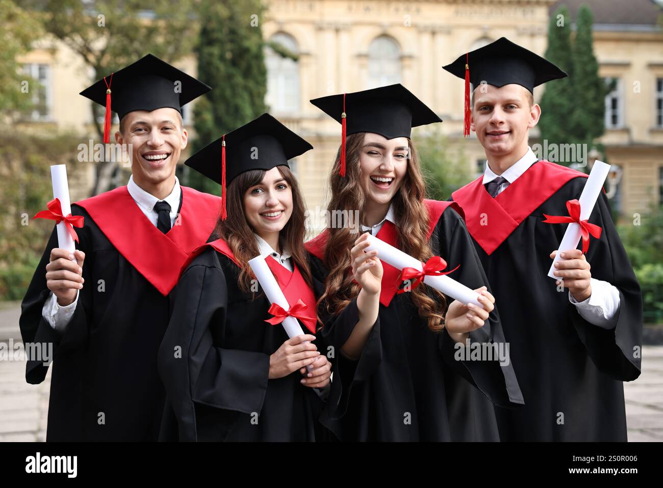 Happy students with diplomas after graduation ceremony outdoors Stock ...