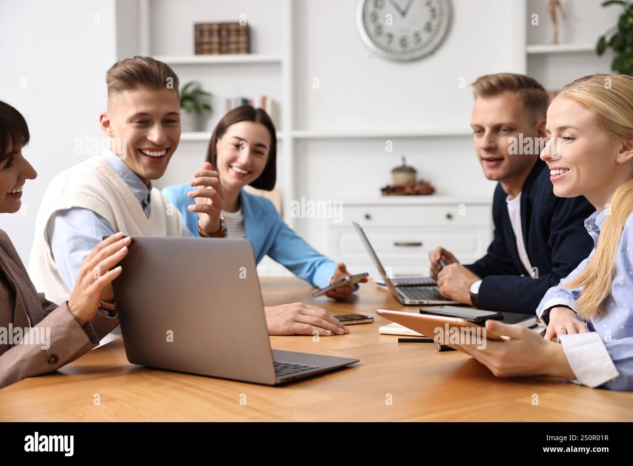 Group of people using different gadgets at wooden table in office ...