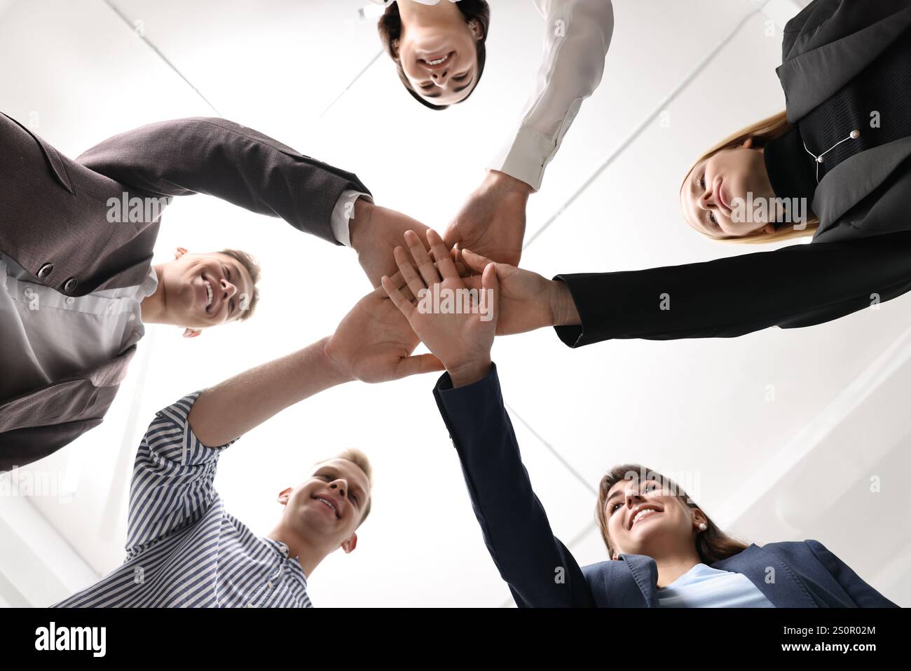 Teamwork. Group of people joining hands together indoors, bottom view ...