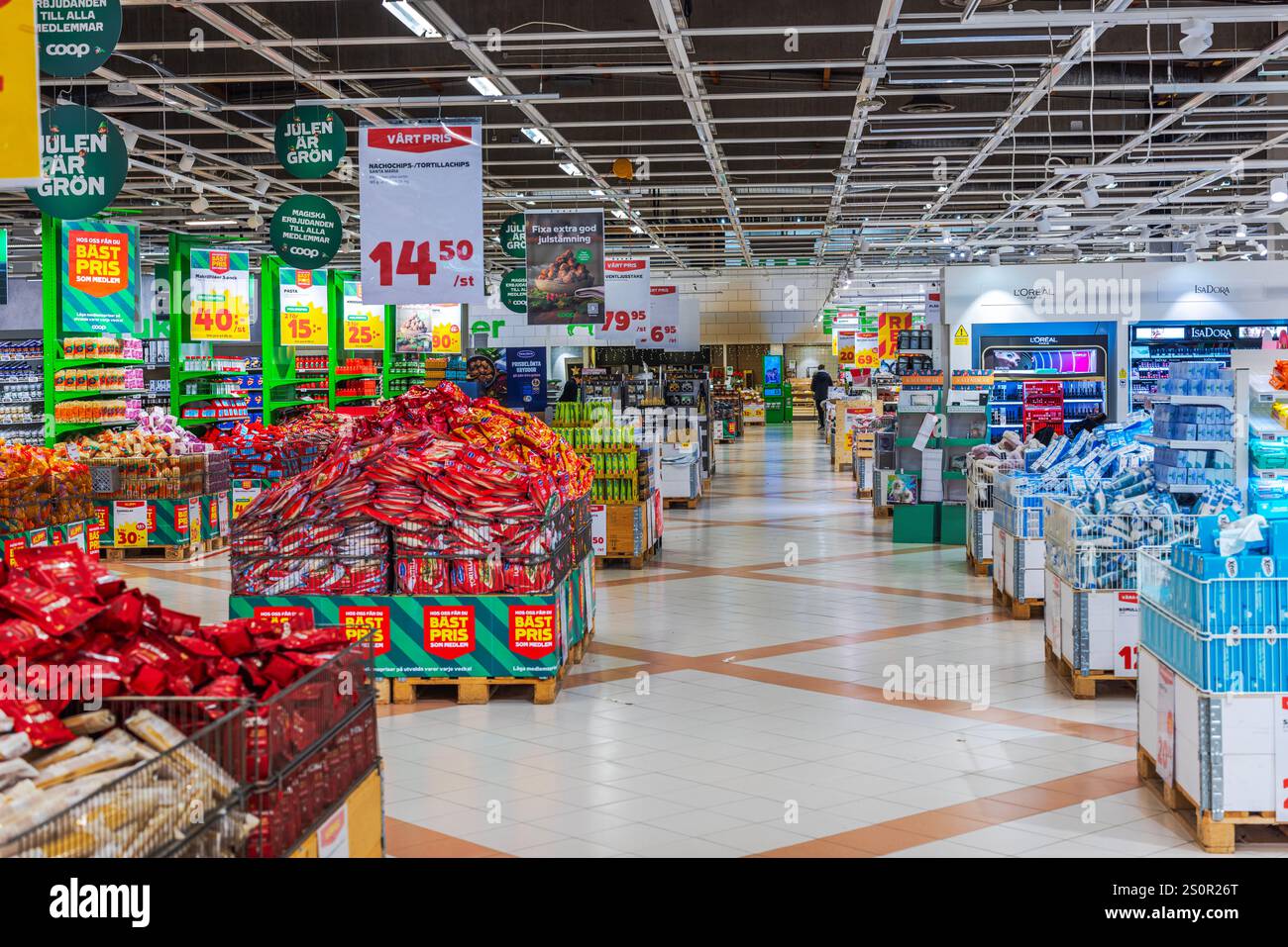 Supermarket aisle with stacked products, promotional signs, colorful ...