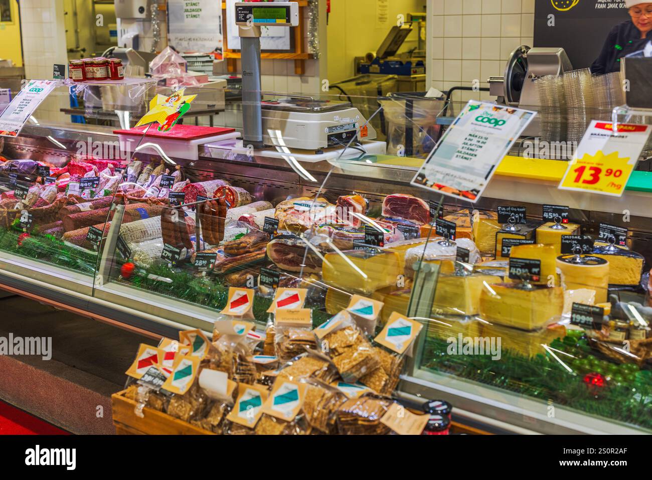 Variety of sausages, cheeses, and packaged snacks displayed in deli ...