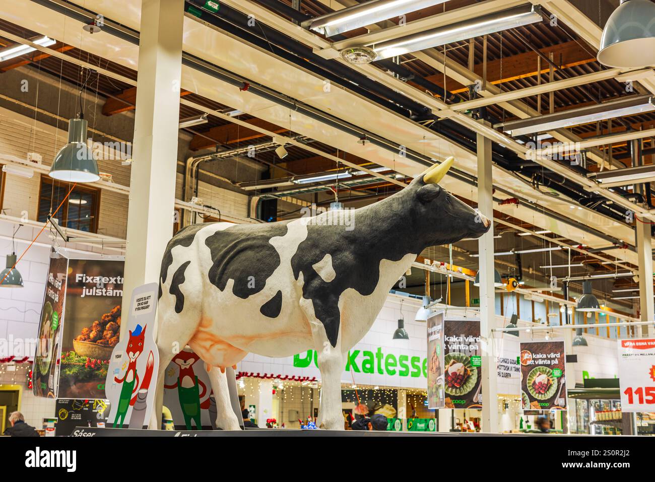 Large black and white cow statue displayed in supermarket under ...