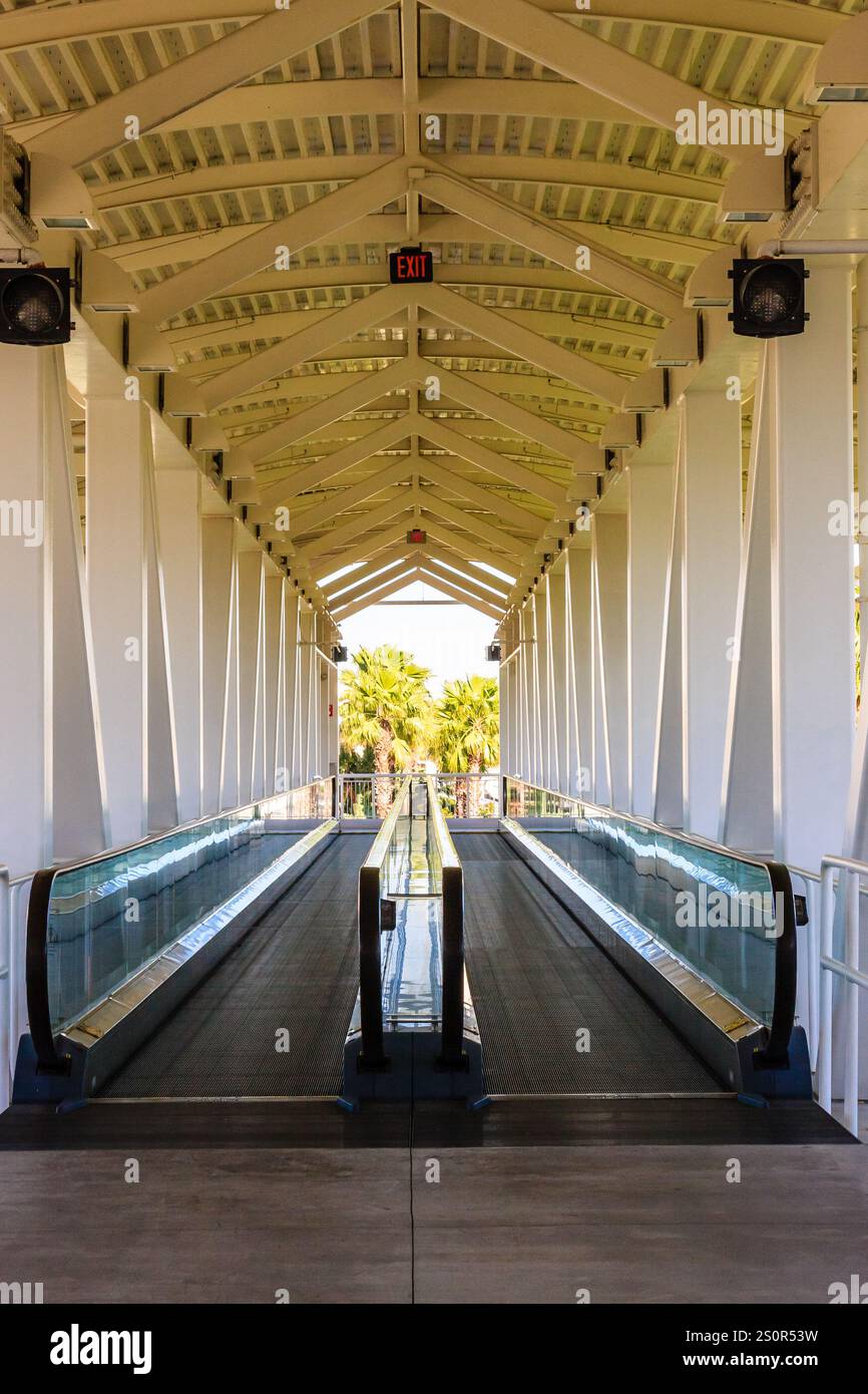 A long, narrow walkway with escalators and a sign that says "Exit ...