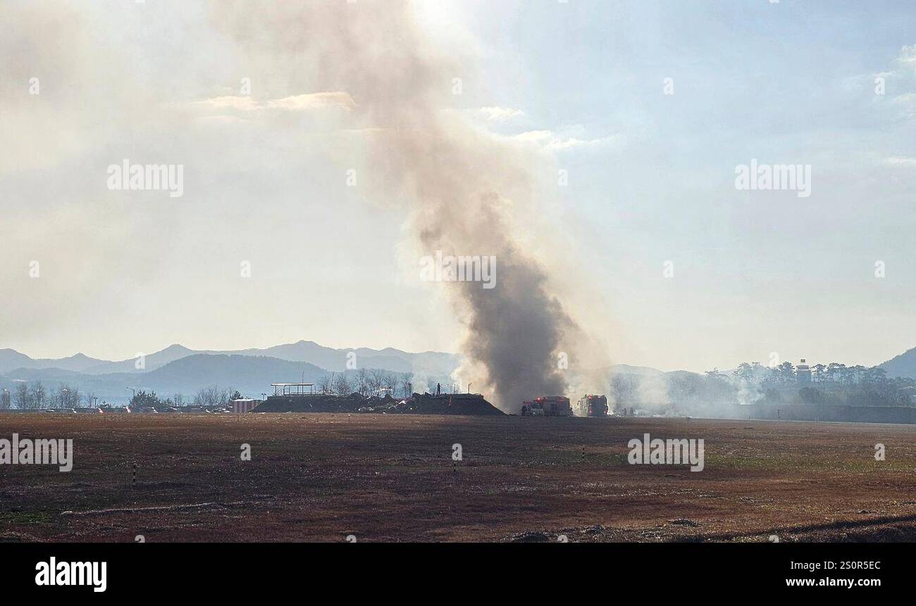 Firefighters work to extinguish a fire off the runway of Muan International Airport in Muan ...