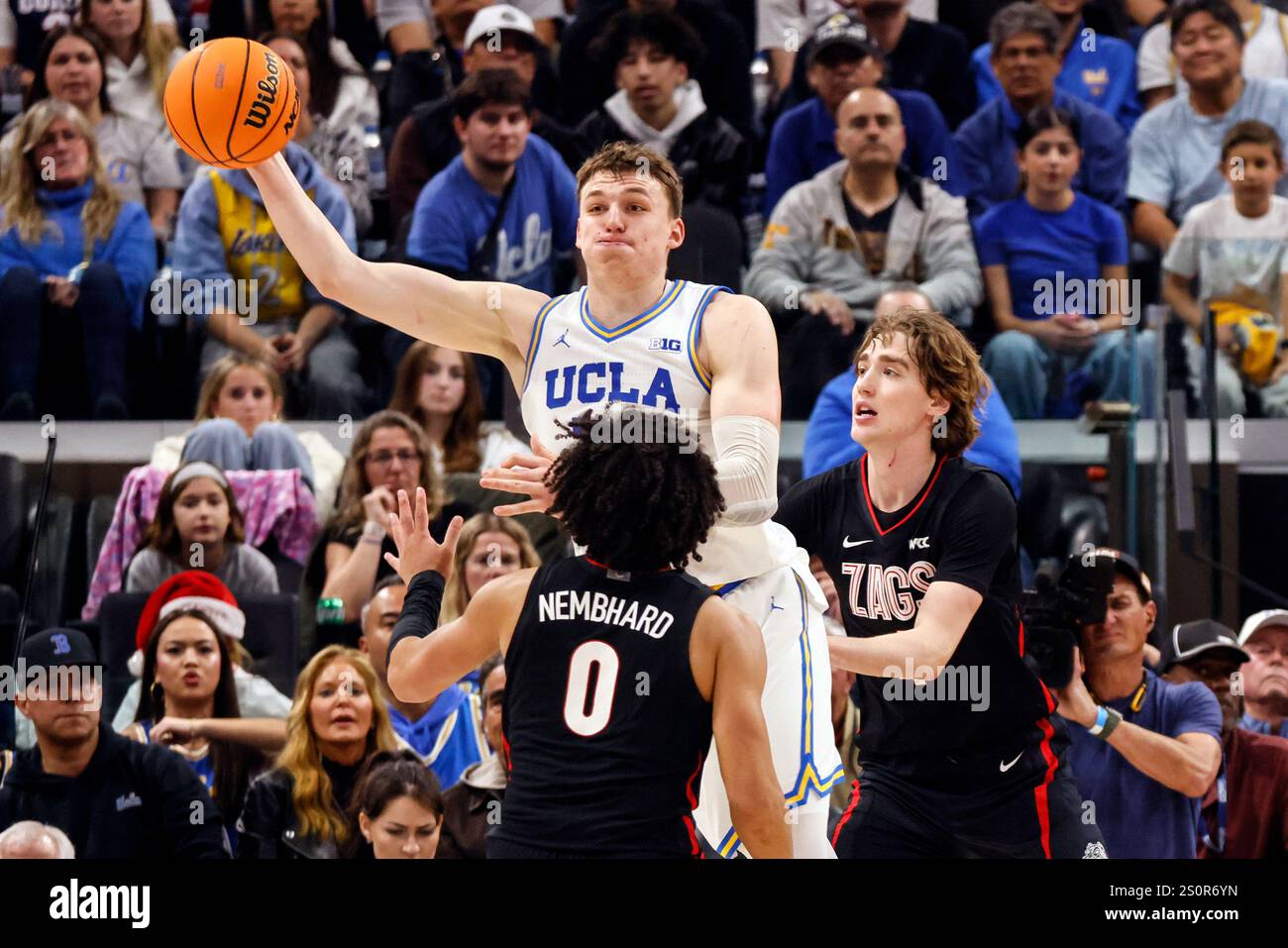 UCLA's Tyler Bilodeau, center, passes the ball to a teammate as he is ...
