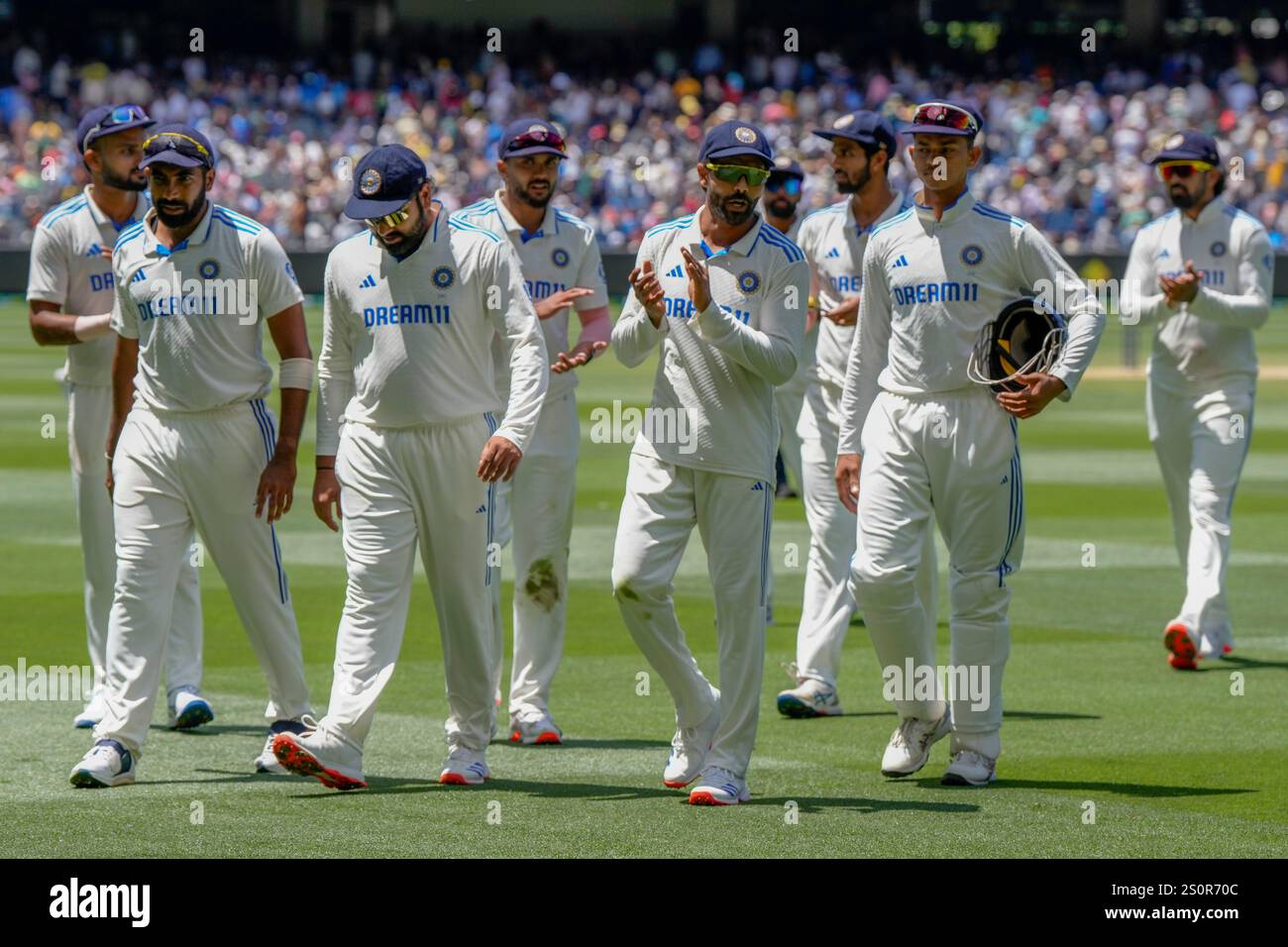 Indian players walk off the field on the lunch break on the day four of ...