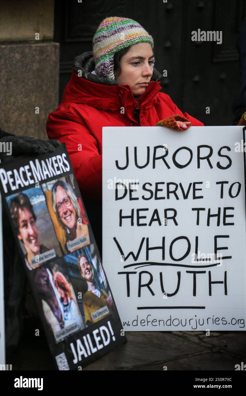 A supporter of Defend Our Juries holds a placard saying "Jurors Deserve ...