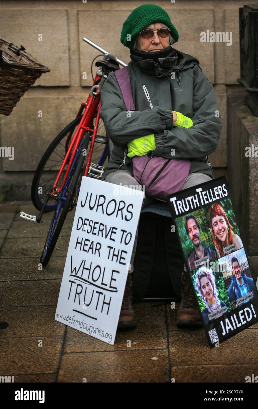 A supporter of Defend Our Juries holds a placard saying "Jurors Deserve ...