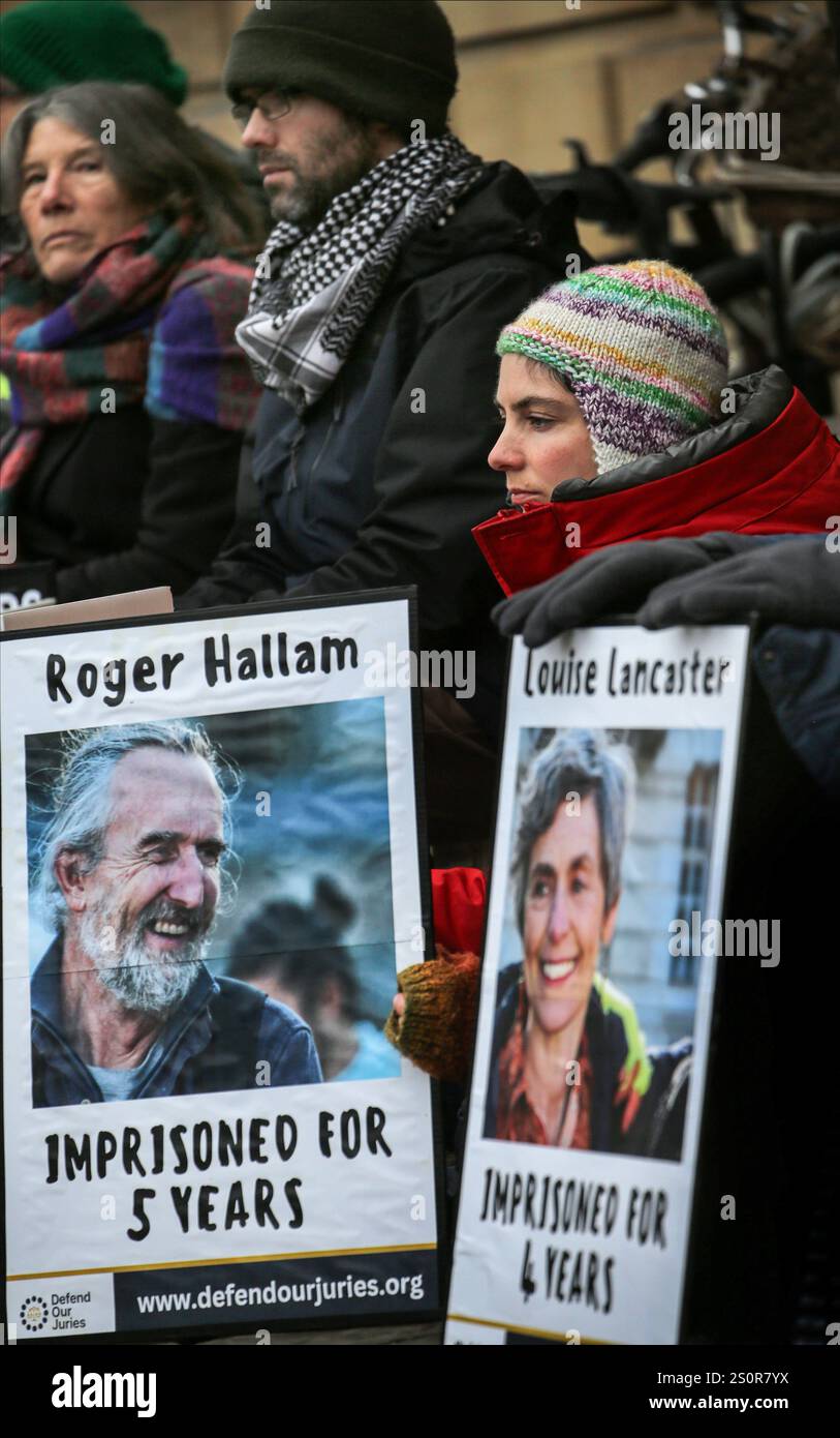 A supporter of Defend Our Juries holds a photo sign of Roger Hallam ...