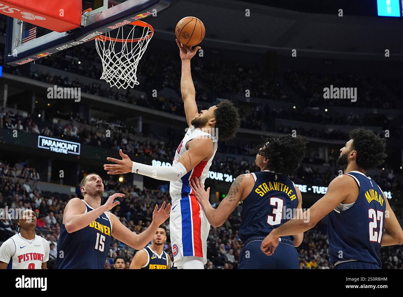 Detroit Pistons guard Cade Cunningham, center, drives to the basket as ...