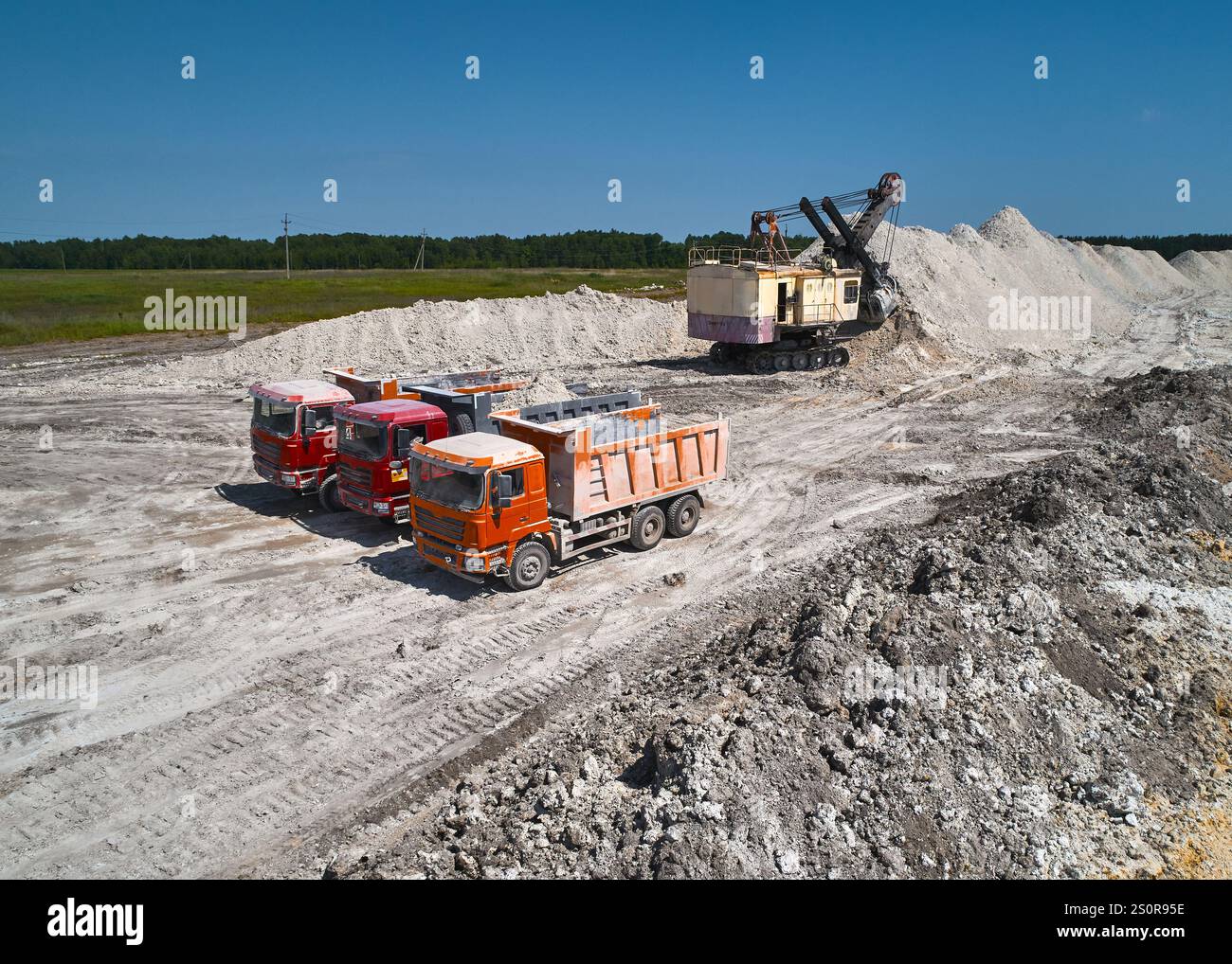 Red tipper trucks and shovel mining excavator in mining quarry Stock ...