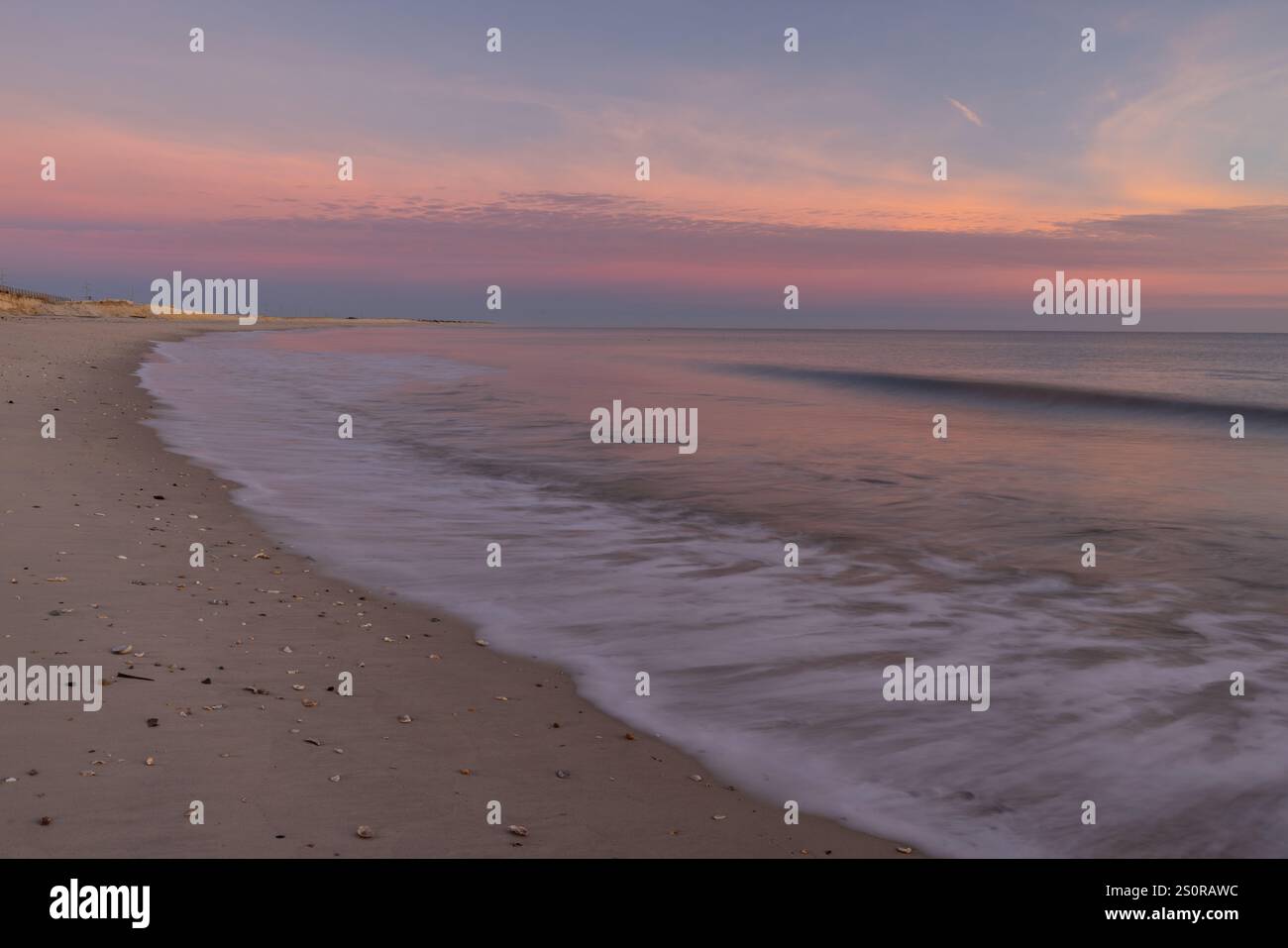 Waves gently lapping the shore at Indian River Inlet at sunrise ...