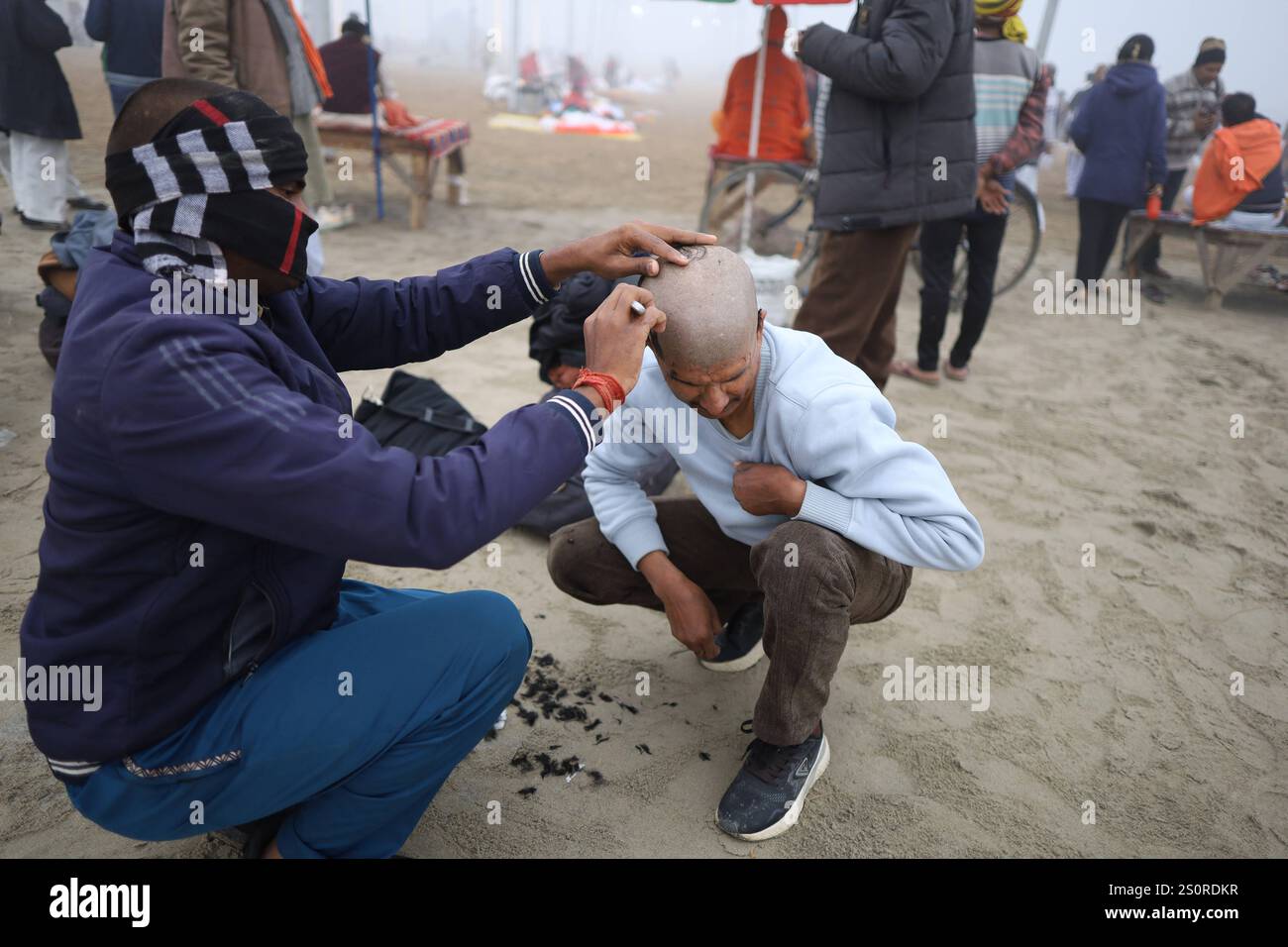 A pilgrim gets his head shave during a hindu ritual at the bank of ...