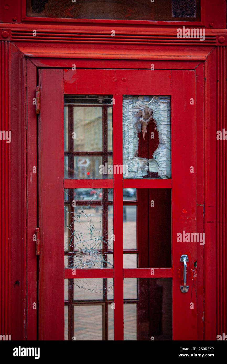 Smashed glass in red telephone box Stock Photo - Alamy