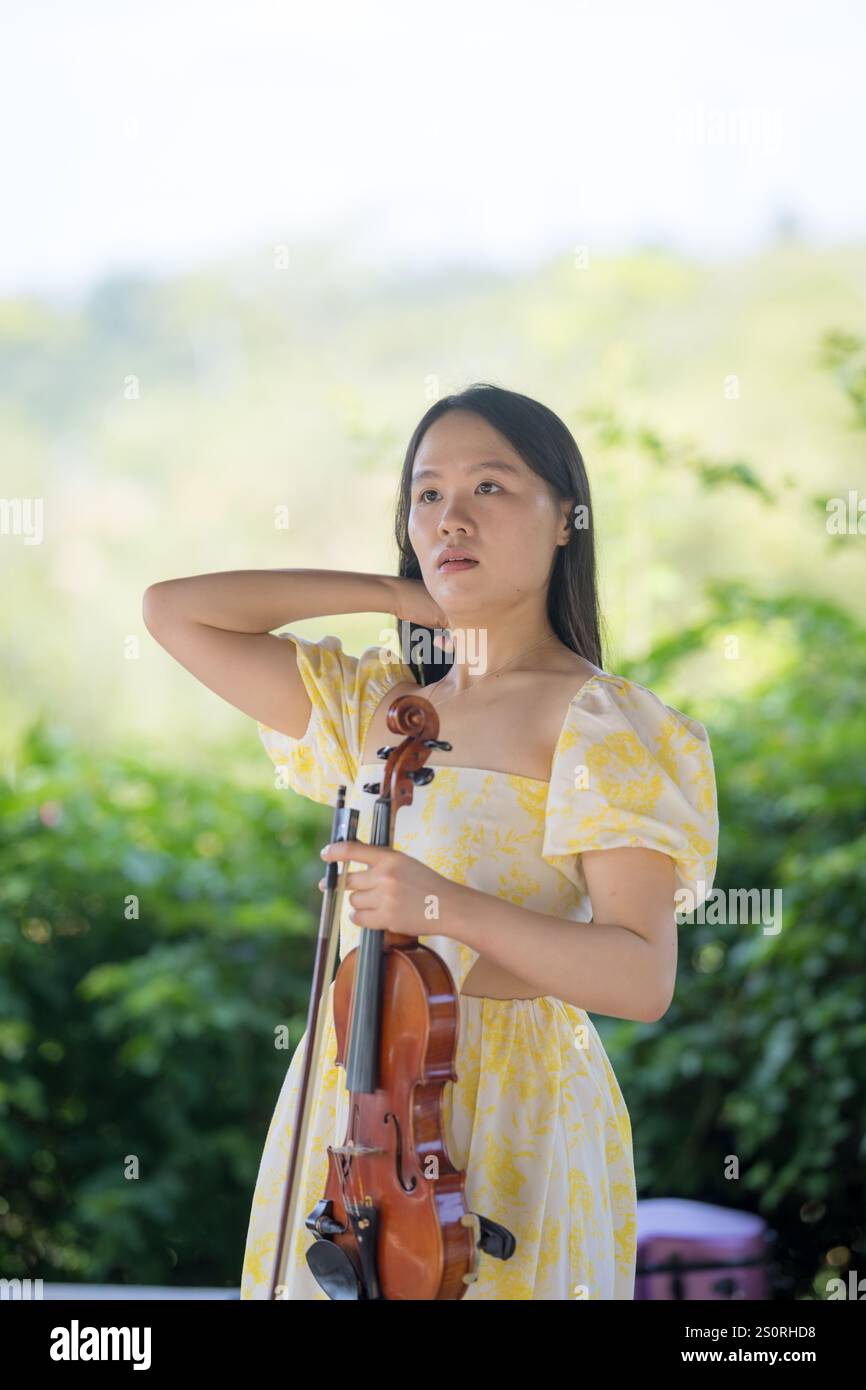 Twenty-something Chinese woman in yellow dress gracefully playing ...