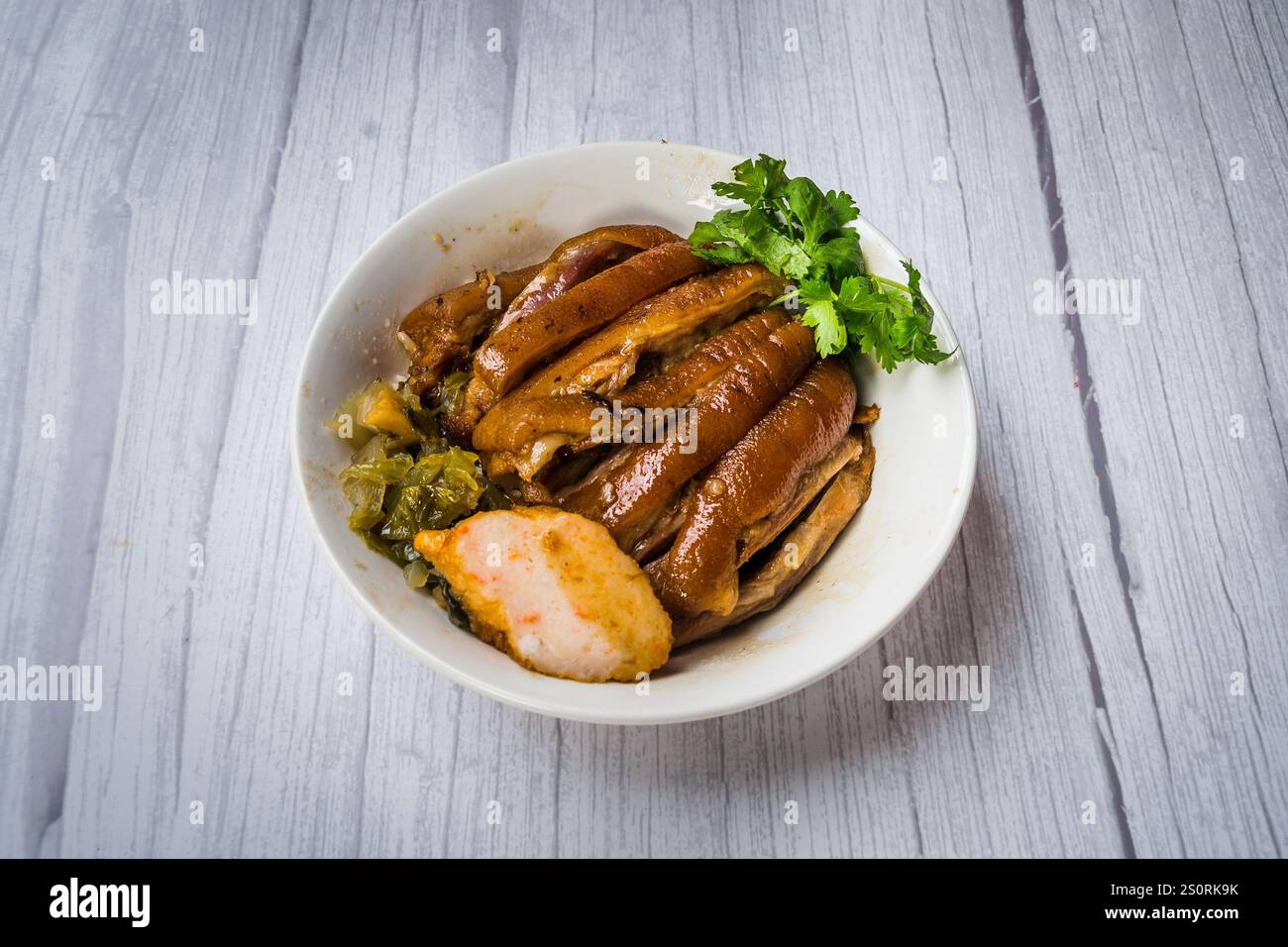 a bowl of pig trotter rice served with salted vegetables and prawn cake ...