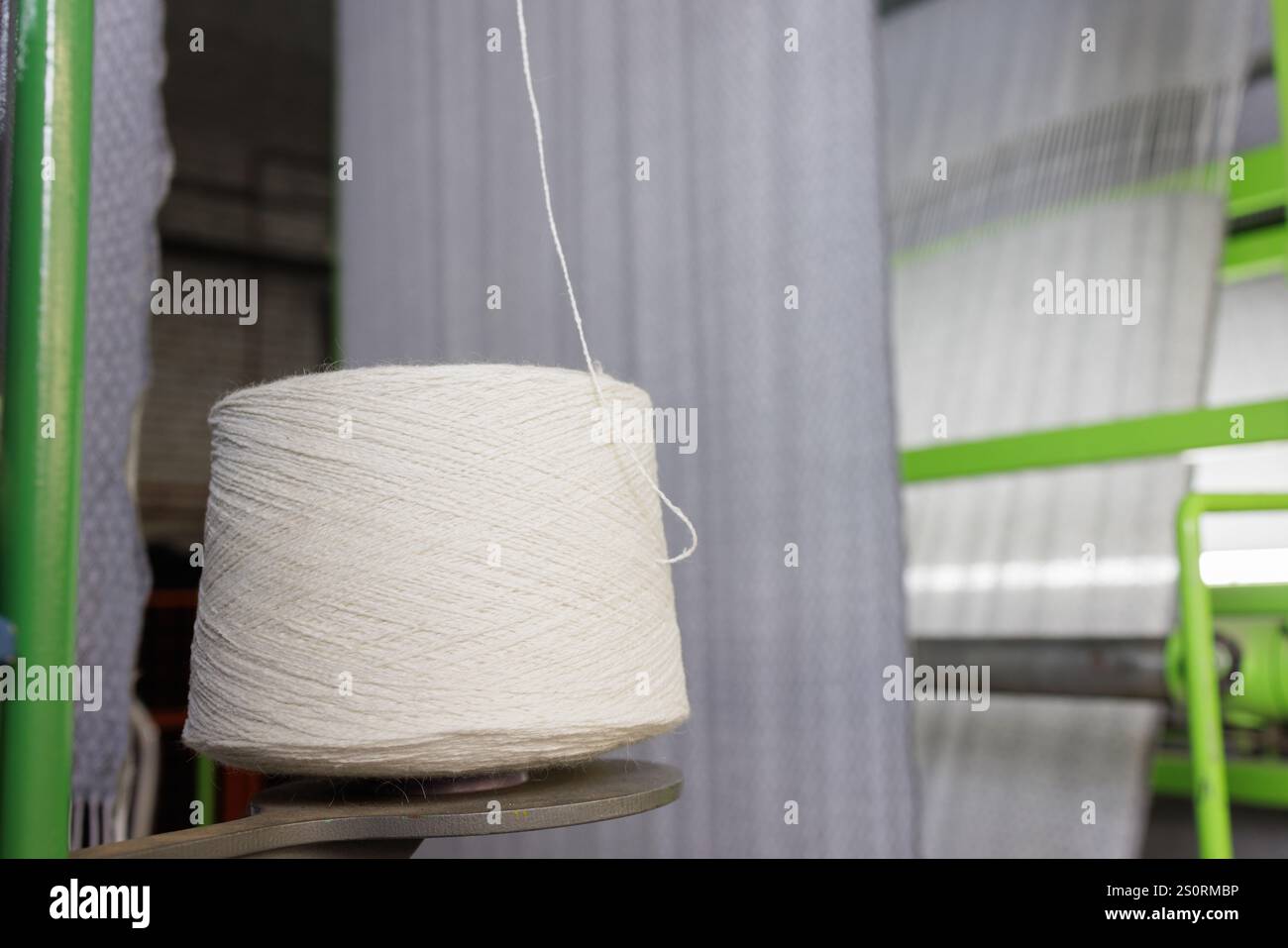 bobbin of white woolen threads in production, weaving machine, cotton ...