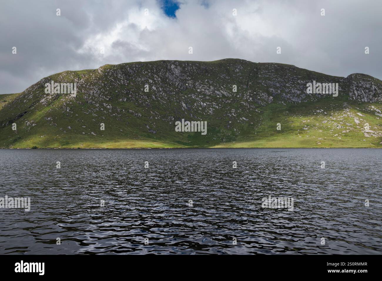 A serene view of Lough Veagh, in Ireland, showcasing tranquil waters ...