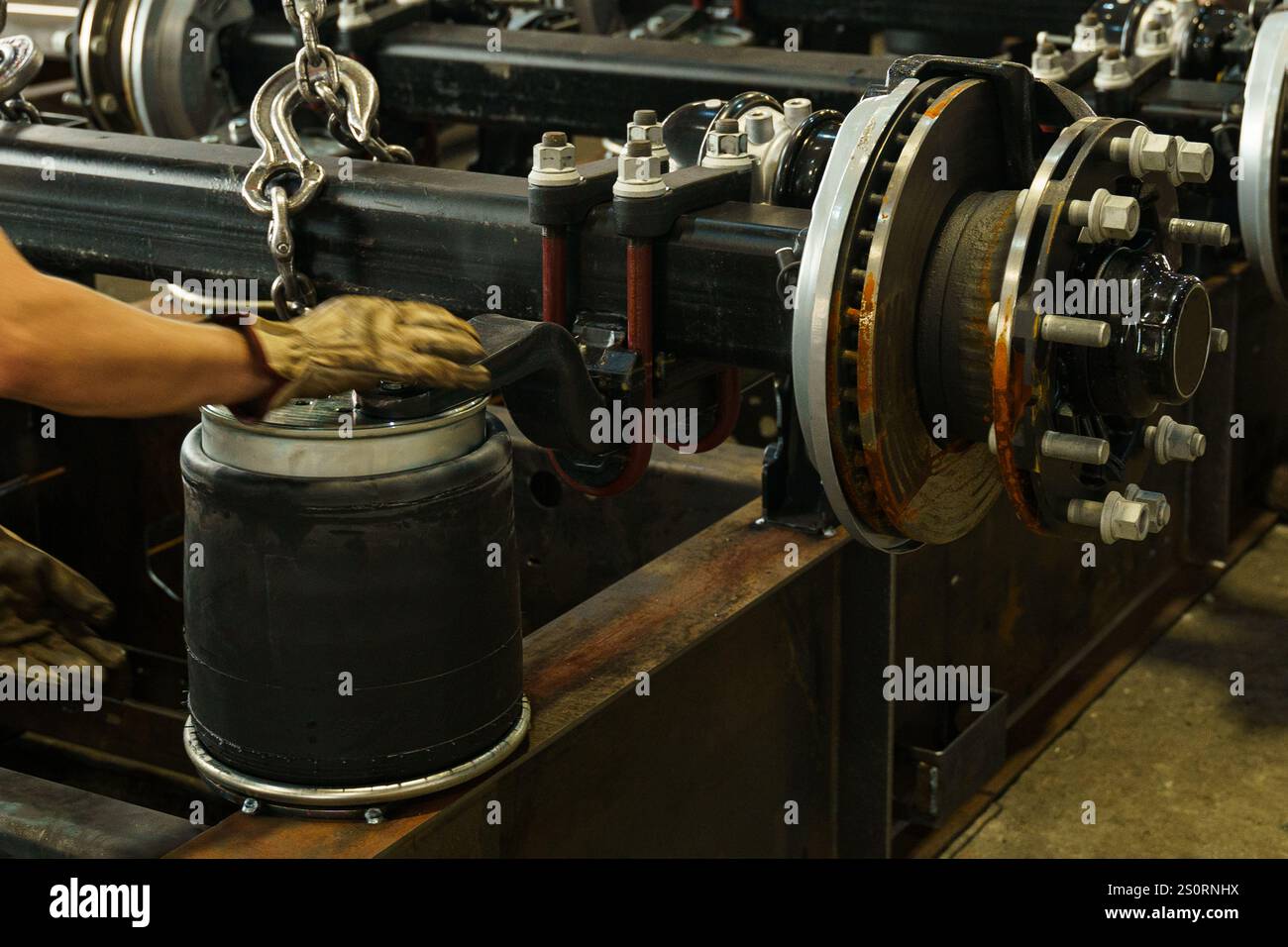 In a bustling workshop, skilled hands carefully handle a heavy ...