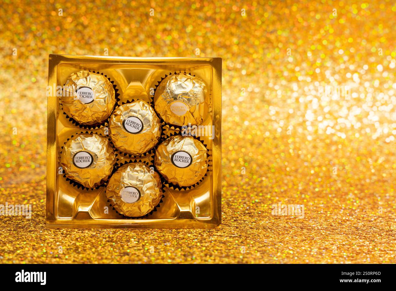 Box of Ferrero Rocher chocolates in gold color with white label. The ...