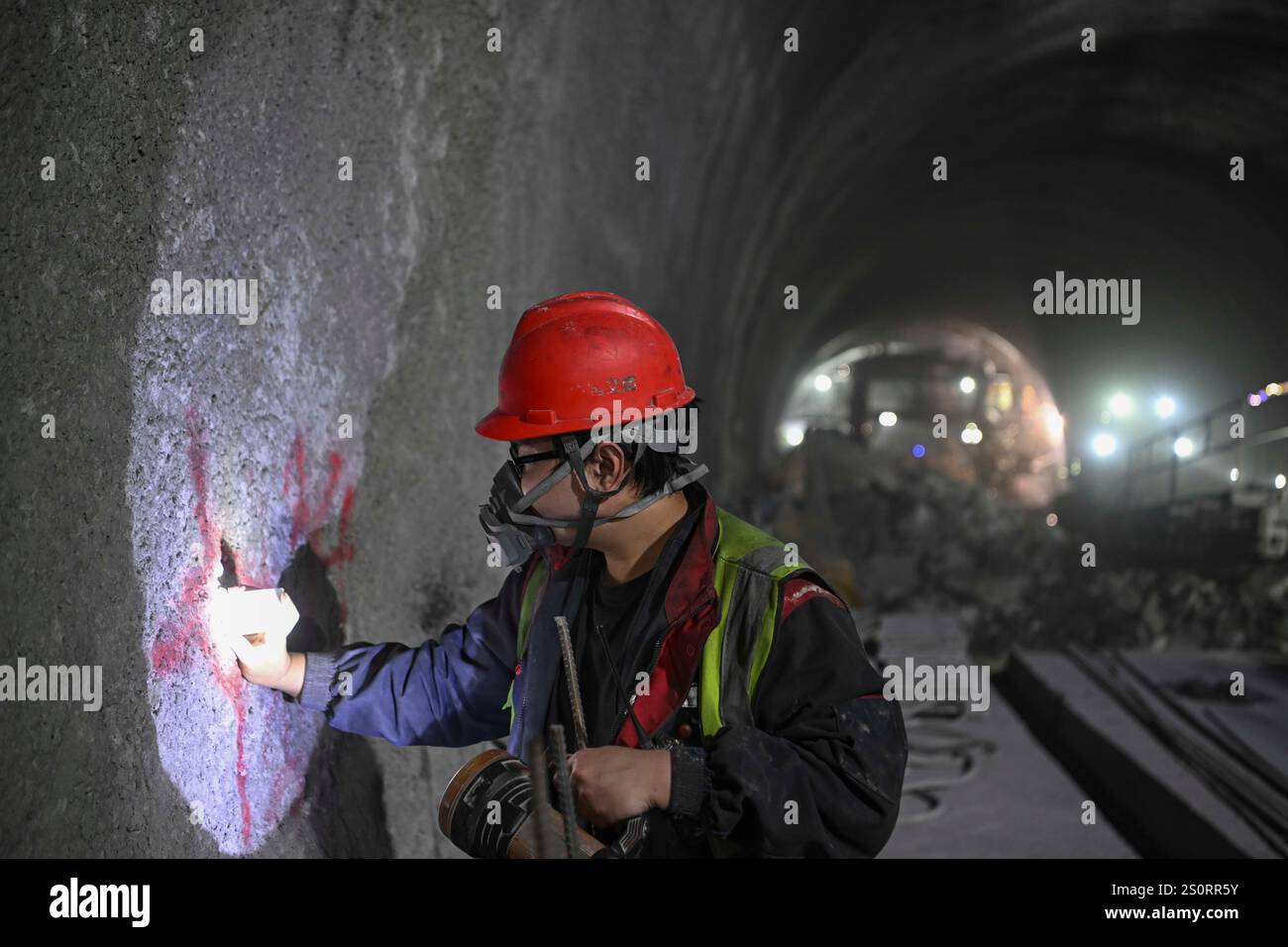 Urumqi. 25th Dec, 2024. A worker takes measurements at the construction ...