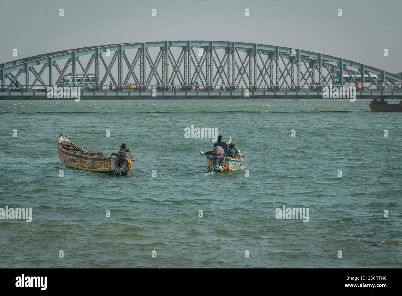 Typical senegalese fishermen with boats called pirogue floating towards ...