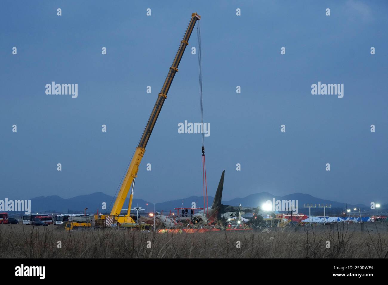 Rescue team members work at the site of a plane fire at Muan ...