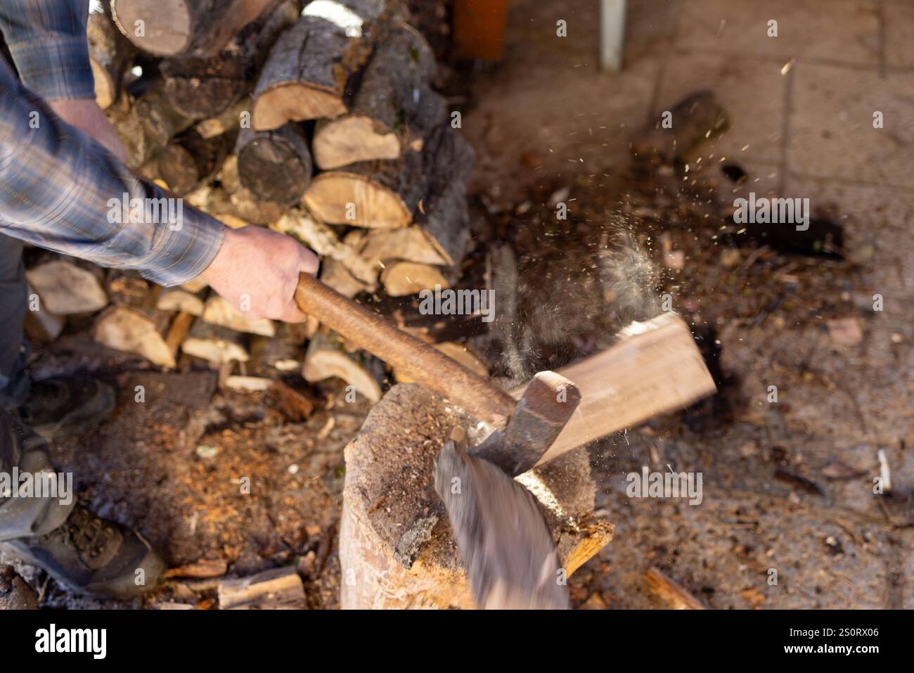Man Splitting Firewood with an Axe on a Tree Stump Stock Photo - Alamy