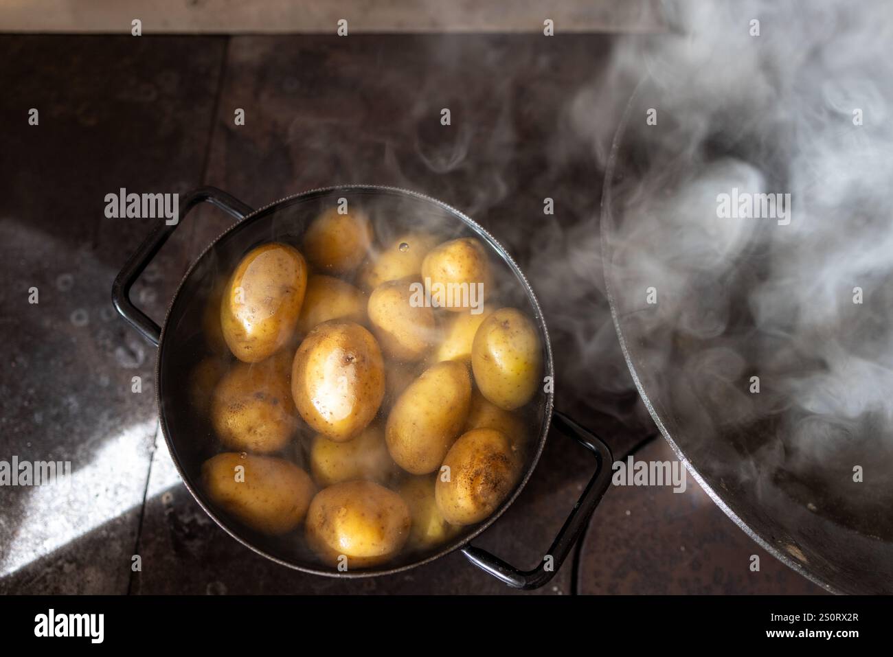 Steaming Pot of Boiled Potatoes on a Stovetop Stock Photo - Alamy