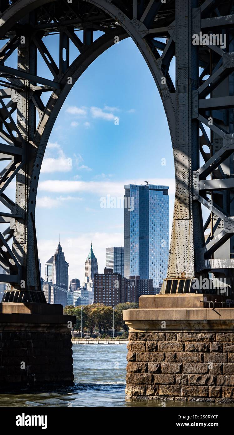 A view of a city skyline framed by the arch of a bridge. The skyline ...