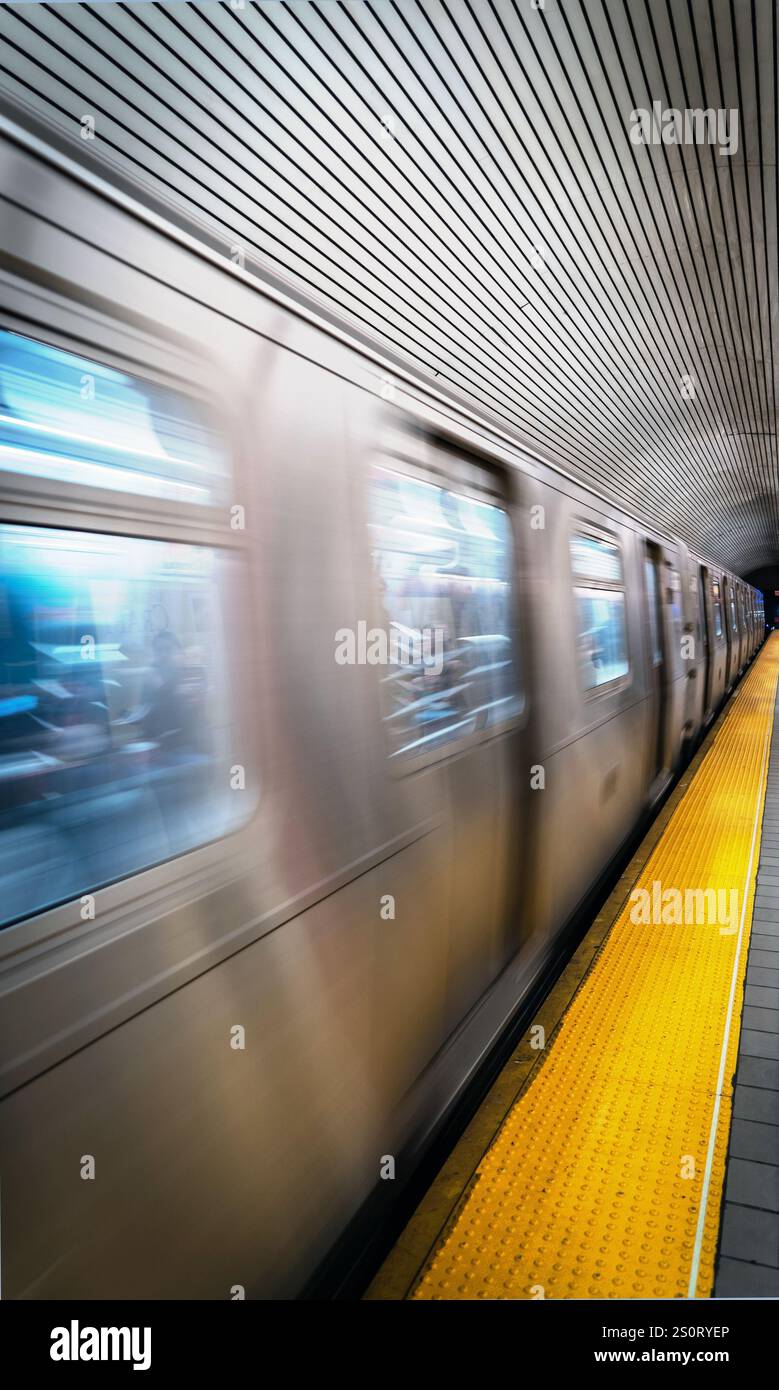 A blurred subway train passing through a station, with a focus on the ...