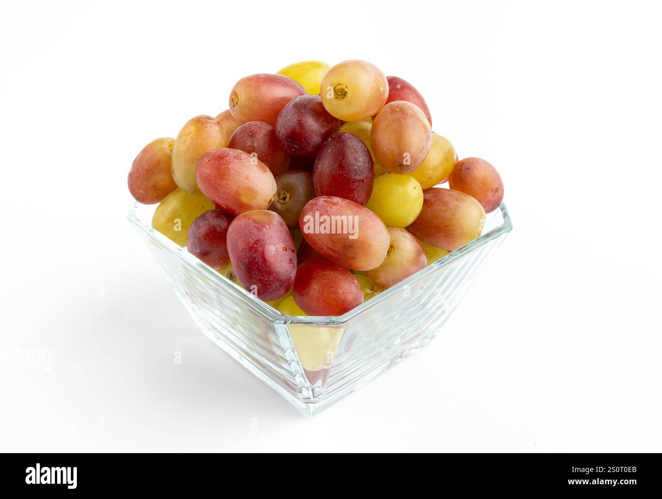Fresh red and yellow grapes in a glass container, placed on a ...