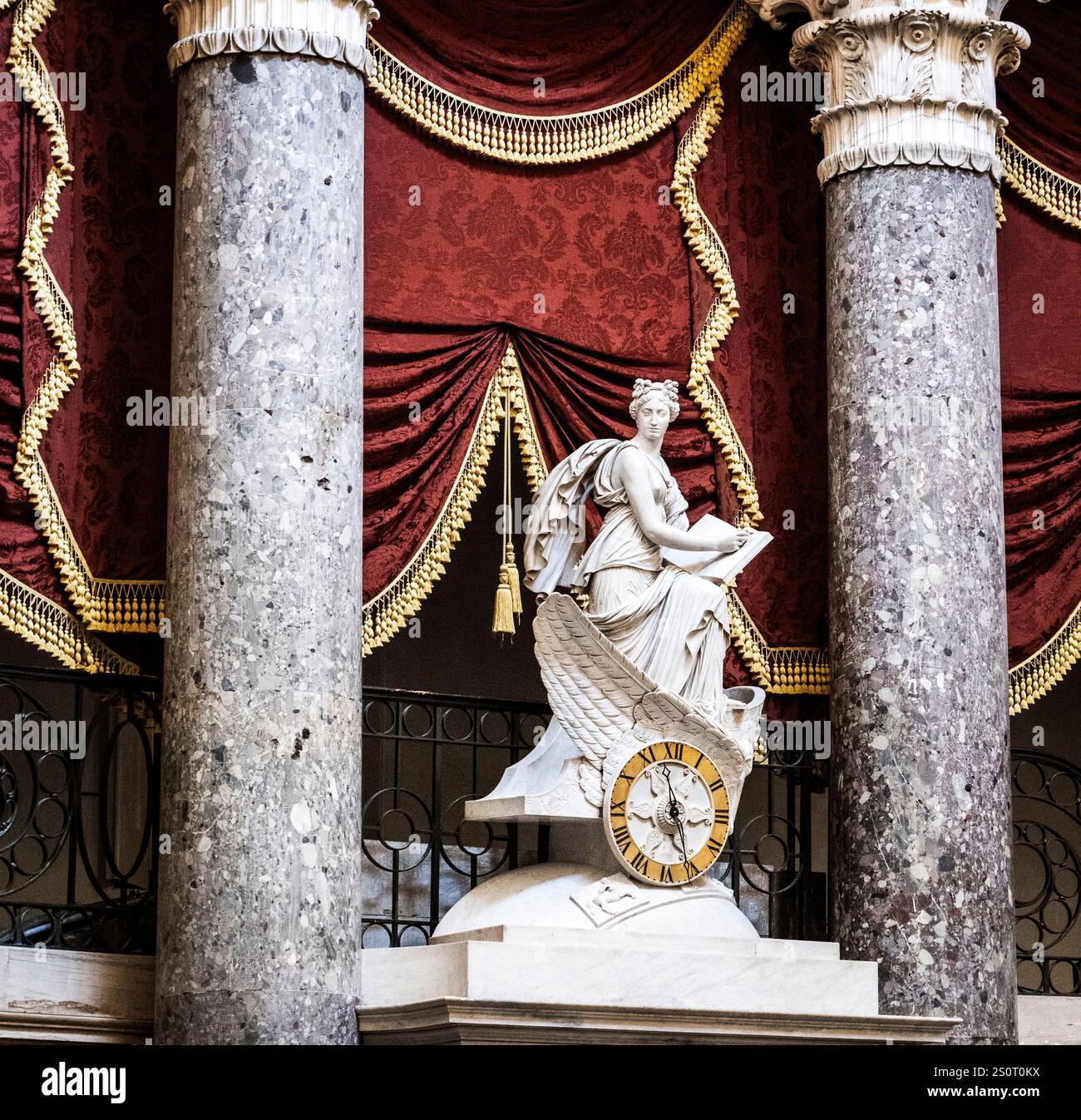 A marble statue of a winged figure holding a book, positioned on a ...