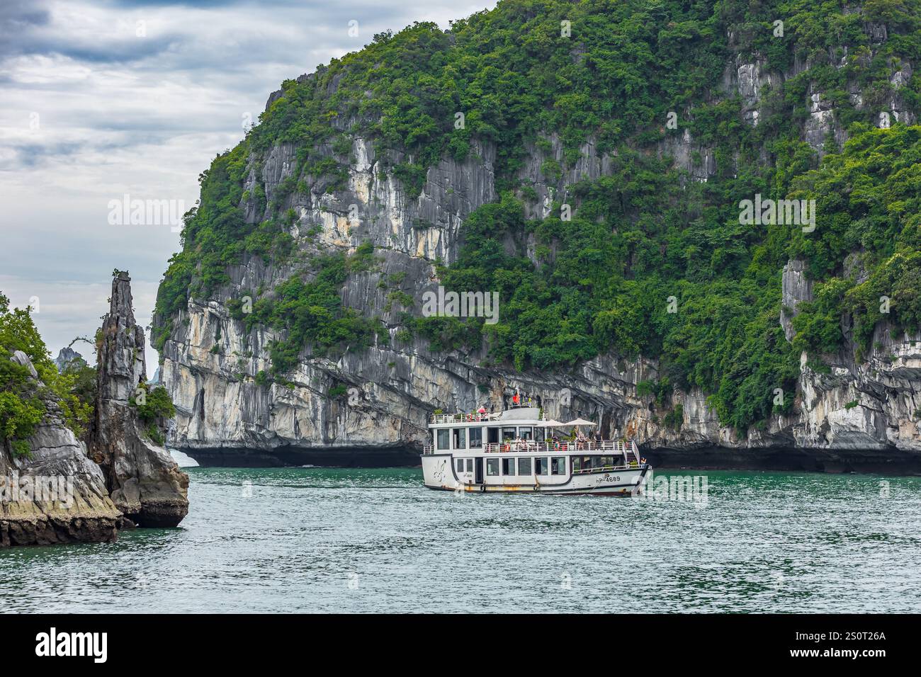 Cruise boat sailing among the rocks of Cat Ba island. A tour boat with ...