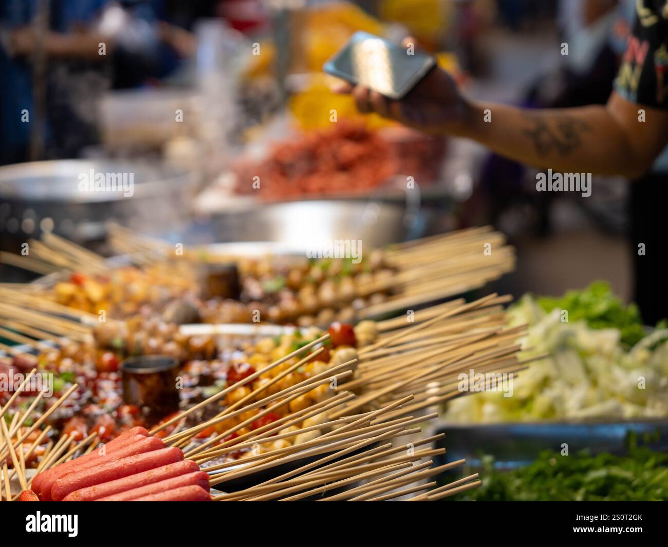 Stewed pot with meatballs and sausages skewers in hot spicy red sauce ...