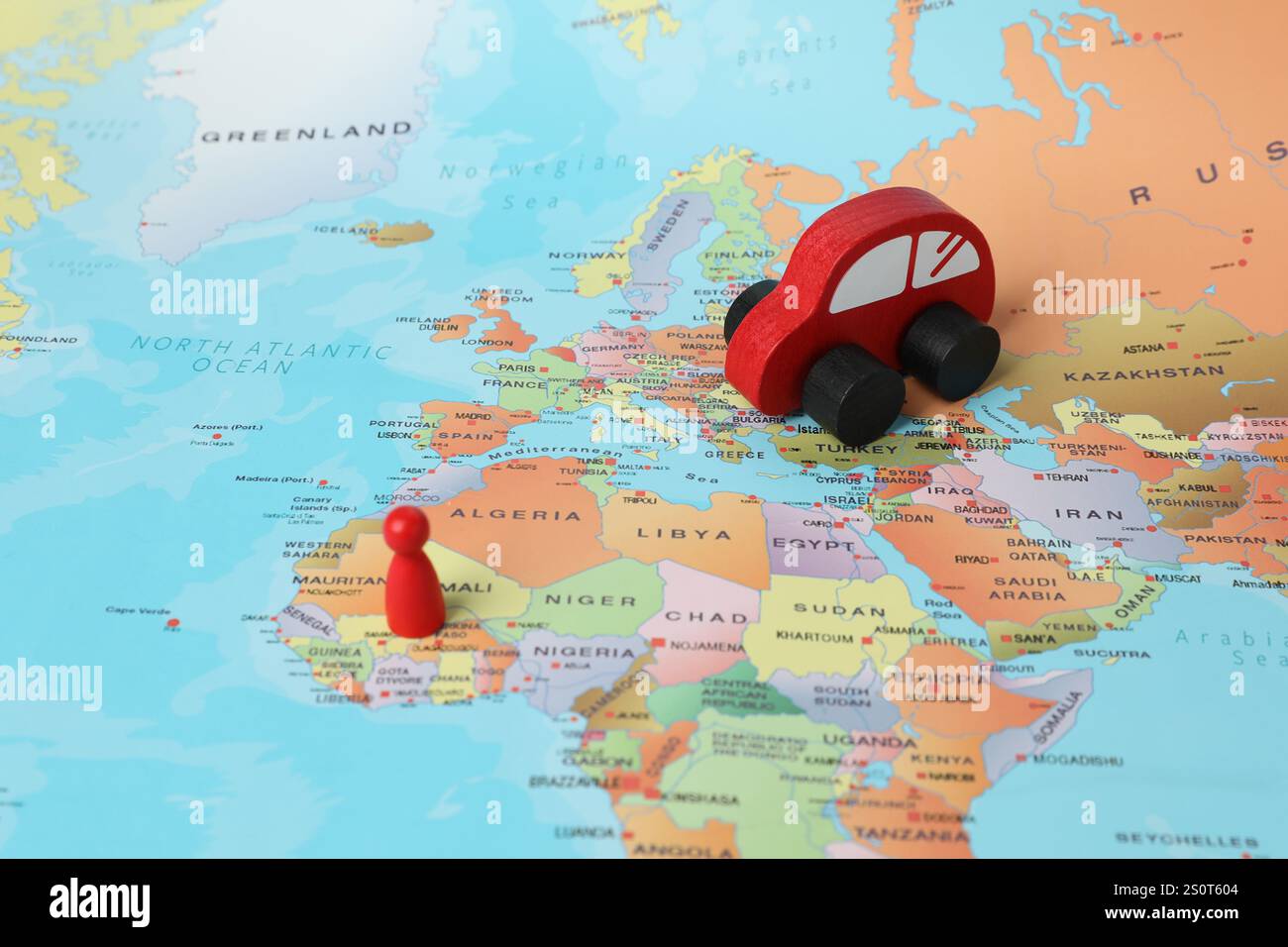 Red wooden toy car and human figure on world map. Road trip Stock Photo ...