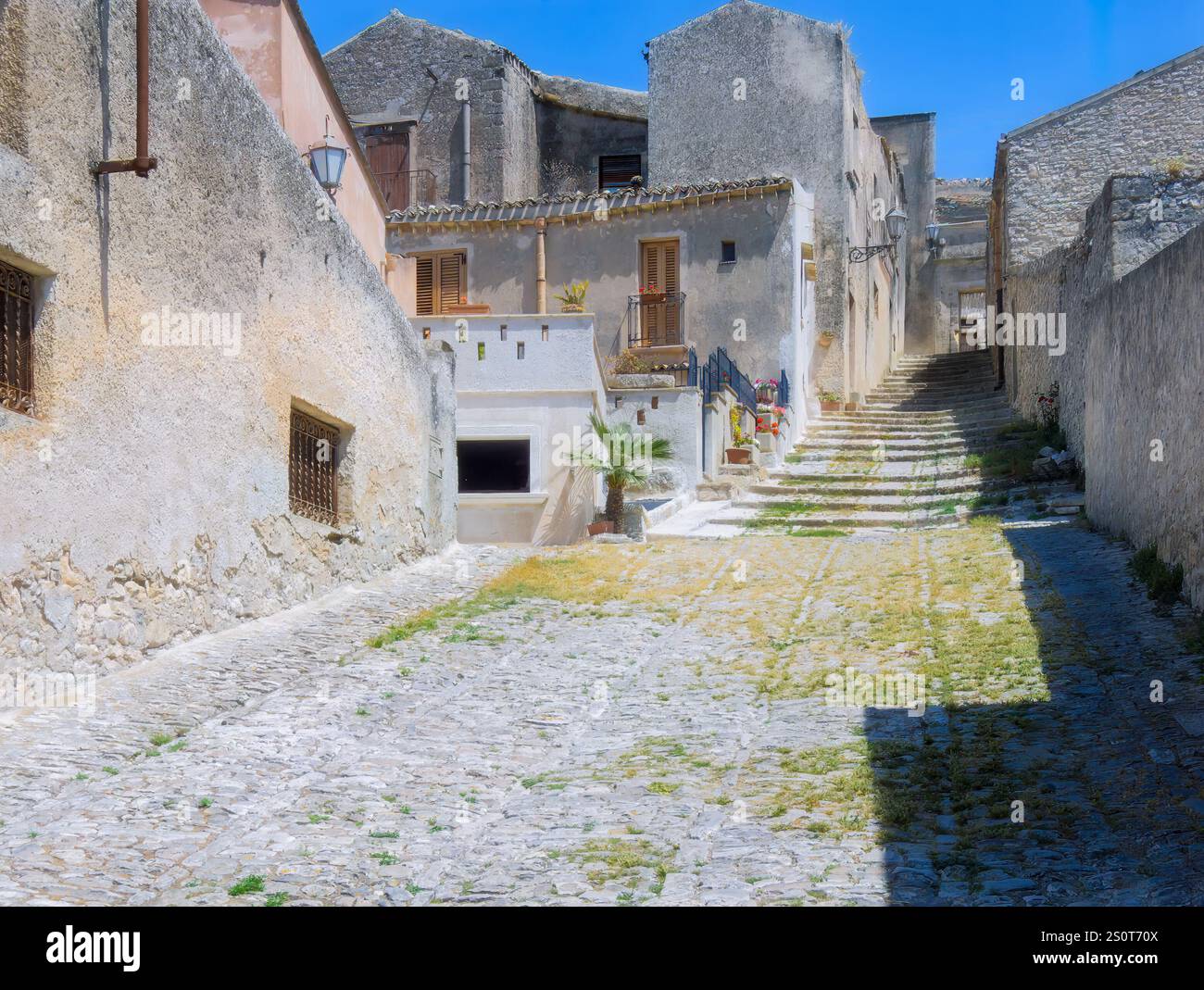 A charming cobblestone street in Erice with rustic stone houses ...
