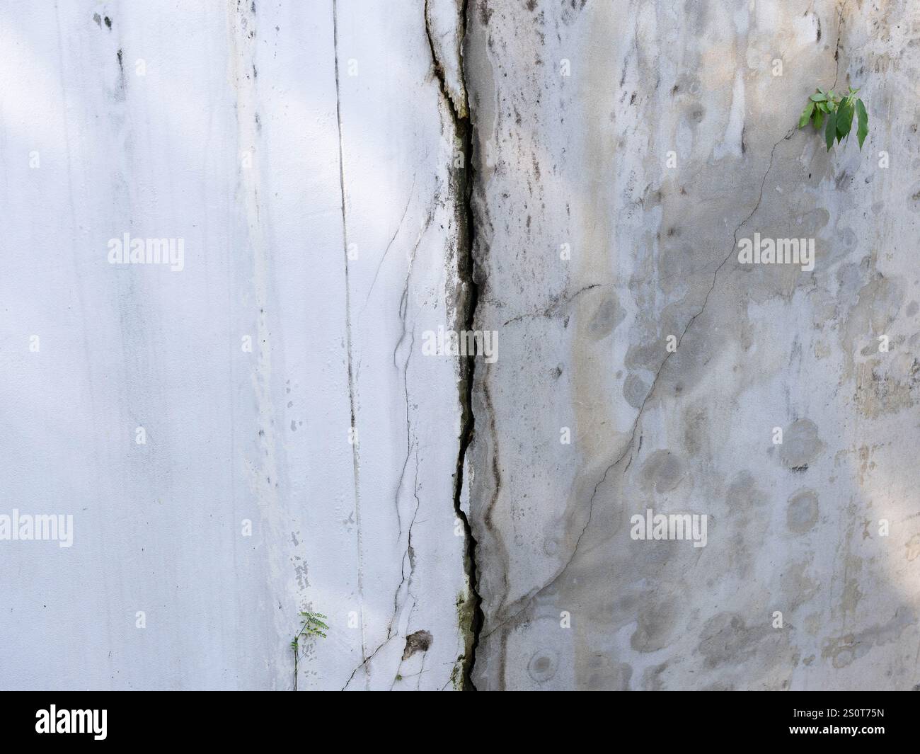 Grey cement walls of the house have dark cracks. Cracked concrete wall ...