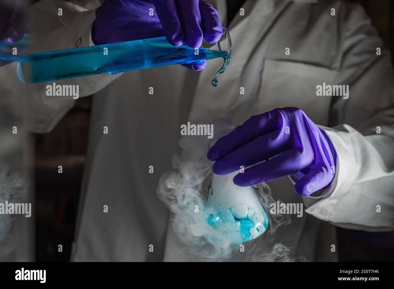 Smoky experiments with blue droplets. Scientist working on chemical ...