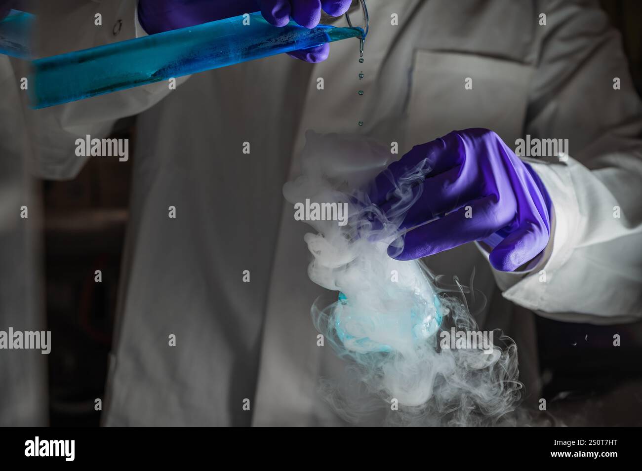 Smoky experiments with blue droplets. Scientist working on chemical ...