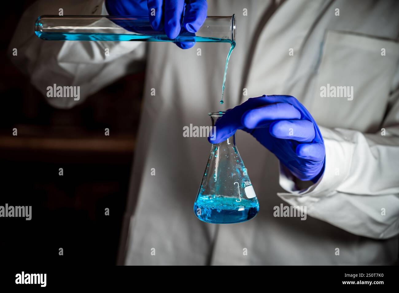 A woman scientist pouring Organic chemistry solution in a laboratory ...