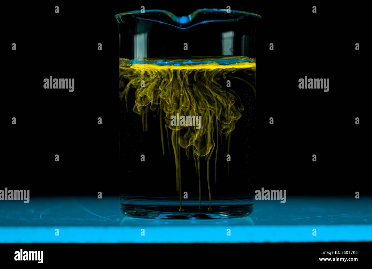 Dissolution and spread of a yellow substance in a flask with a clear ...