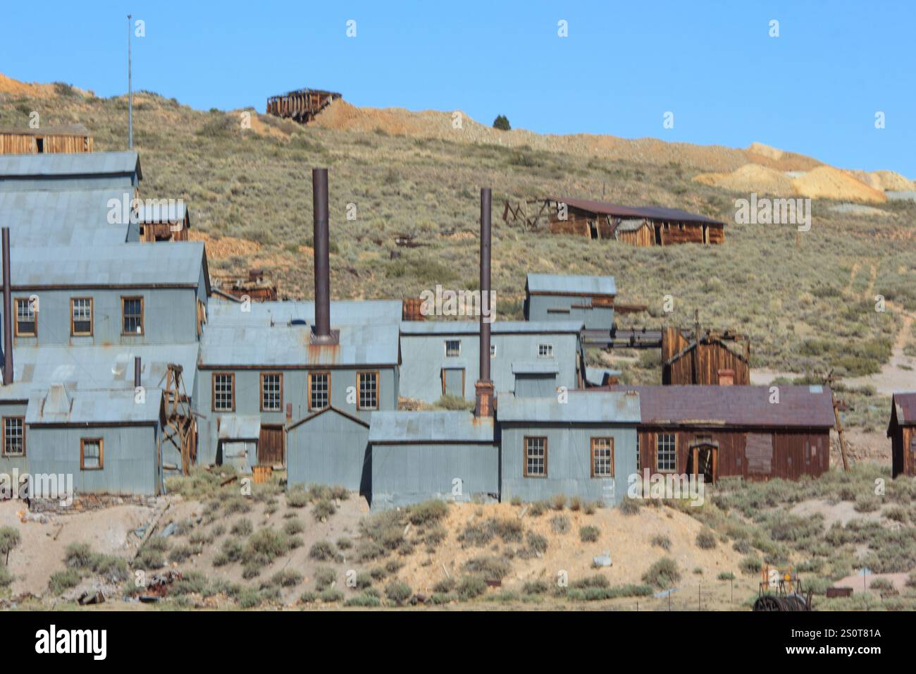 A cluster of old, rusted buildings with numerous windows and chimneys ...